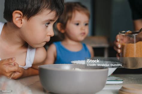 부엌에서 머핀 요리를 배우는 두 명의 작은 백인 아이들 아이들은 재료를 섞을 준비가 되어 있고 컵케이크를 요리할 준비가 되어 있습니다 가족 교육 가족 가정 여가 사람들의