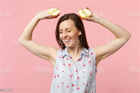 여름 옷에 웃는 젊은 여자 핑크 파스텔 배경에 고립 된 신선한 잘 익은 사과 과일의 Halfs 지주를 유지 사람들은 생생한 라이프 스타일 휴식 휴가 개념입니다 복사 공간을