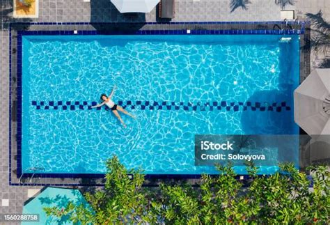 하얀 수영복을 입은 젊은 여성이 고급 빌라 수영장에서 휴식을 취하고 있다 공중 평면도 샷 부주의한 여름 휴가 컨셉 이미지 수영장 스포츠 경기장에 대한 스톡 사진 및 기타