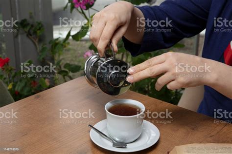 겨울 차 개념입니다 여자 손 소녀는 찻잔에 투명 유리 주전자에서 레몬과 오렌지와 감귤 류 과일 차를 붓는 다 가을에 대한 스톡