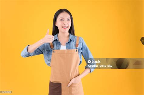 예쁜 아시아 여성 스마일 커피 프리랜서 자신의 커피 바 숍은 커피 종이 컵을 들고 자신의 상점 노란색 배경에서 신용 카드를 스 와이프하는 단말기 돈을 통해 신용 카드로