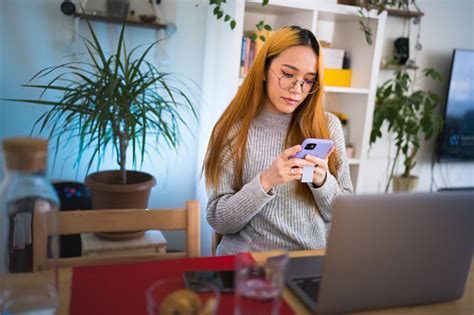 휴대 전화를 사용하고 집에서 노트북으로 작업하는 태국 여성 25 29세에 대한 스톡 사진 및 기타 이미지 25 29세 Brand Name Online Messaging