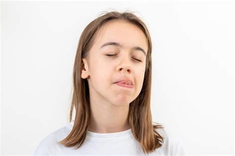 Free Photo Funny Teenage Girl Licks Her Lips On A White Background