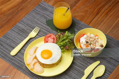 어린이 메뉴 햇볕이 잘 드는 쪽이 위로 향하고 쌀 그린 샐러드 요거트가 들어간 뮤즐리가 레스토랑 테이블에 제공되며 플라스틱 어린이 친화적인 식사 기구가 있습니다 달걀부침에