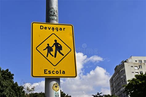Traffic Sign With Information In Portuguese Saying Slow School Stock