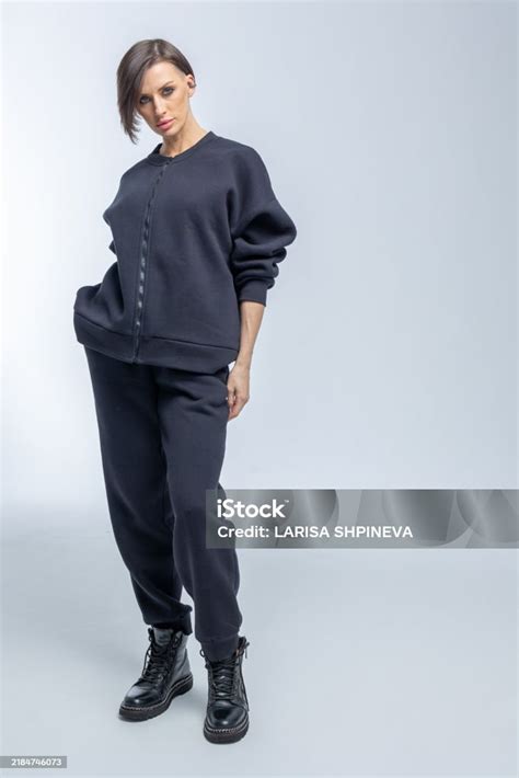 모델 외모의 아름 다운 여성 회색 배경에 검은 옷을 입은 소녀 스튜디오에서 포즈를 취하는 트렌디한 메이크업을 한 예쁜 여성 세로 사진 Fashionable Mom Show에