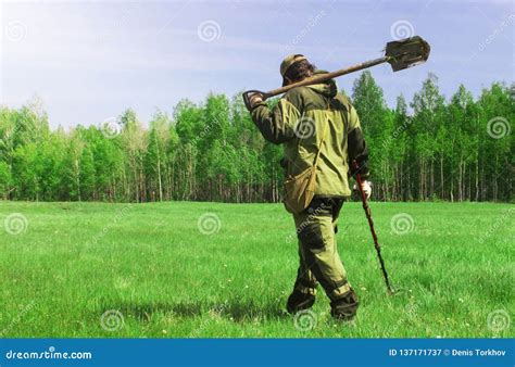 Man On A Treasure Hunt With A Metal Detector In The Woods On The Field
