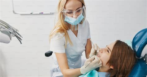 남자 치아 검진 중 치주 프로브와 거울을 사용하여 얼굴에 플라스틱 방패와 마스크를 착용한 여성 치과 의사 사진 Unsplash의 건강 검진 이미지