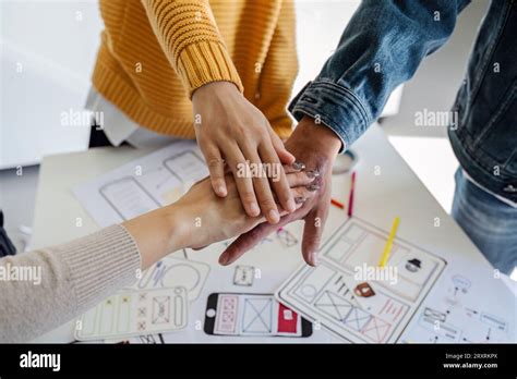 Asian Ux Developer And Ui Designer Team Stacking Hands Together