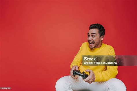 빨간 배경에 조이스틱을 들고 비명 갈색 머리 남자의 절반 길이 Brand Name Video Game에 대한 스톡 사진 및 기타 이미지 Brand Name Video