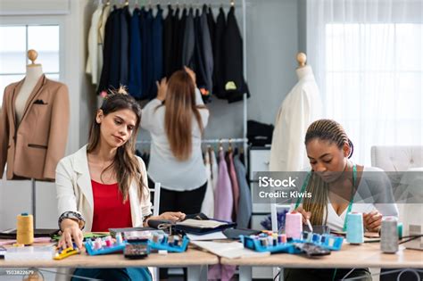 다양한 여성 패션 디자이너는 테일러링 아틀리에에서 옷을 디자인합니다 매력적인 젊은 여성 재단사 양장점 팀은 행복을 느끼고 워크샵