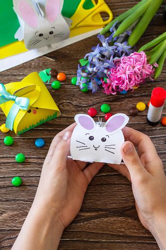 아이는 부활절 토끼와 부활절 병아리와 과자를 포장하기위한 상자를 보유하고 있습니다 Handmade 어린이의 창의력 수공예품 어린이를 위한 공예품 프로젝트 개념에 대한 스톡