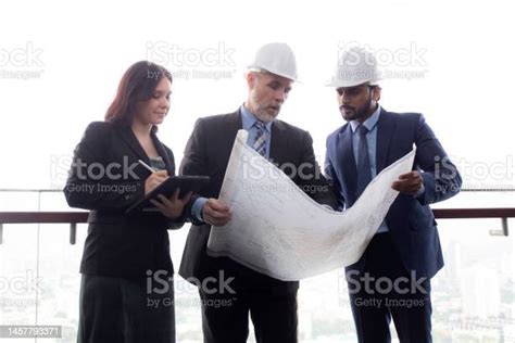 수석 건축가 및 비서 검사관은 사무실 임원 및 감독자 또는 엔지니어 계획 프로젝트 산업 및 건설 개념에서 계약자와 함께 청사진 및 구조를 확인합니다 3 명에 대한 스톡 사진