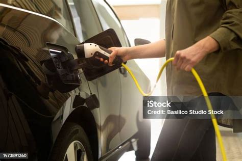집에서 전기 자동차 소켓에 충전기를 연결하는 여성 손의 클로즈업 전기 자동차 대체 연료 자동차에 대한 스톡 사진 및 기타 이미지 전기 자동차 대체 연료 자동차 충전
