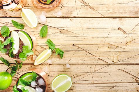 라임 얼음 생강 맥주 보드카 민트가 있는 구리 머그잔에 모스크바 뮬 칵테일 나무 배경 바 도구 네거티브 공간 Topv 보기