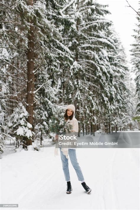 젊은 여성은 목에 스카프를 두르고 머리에는 모자를 쓴 채 눈 속에 서 있습니다 20 24세에 대한 스톡 사진 및 기타 이미지 20 24세 감정 겨울 Istock