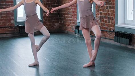 Two Ballerina Girls Training Synchronized Movements In The Studio Stock