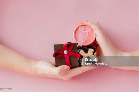 분홍색 배경에 여성의 손에 작은 선물 상자 발렌타인 데이 어머니의 날 또는 생일을 위한 축제 컨셉 0명에 대한 스톡 사진 및 기타 이미지 Istock