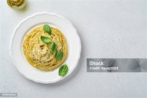 페스토 소스를 곁들인 파스타 스파게티와 흰 그릇에 신선한 바질 잎 회색 배경 모의 맨 위 보기입니다 저녁 식사에 대한 스톡 사진 및 기타 이미지 Istock