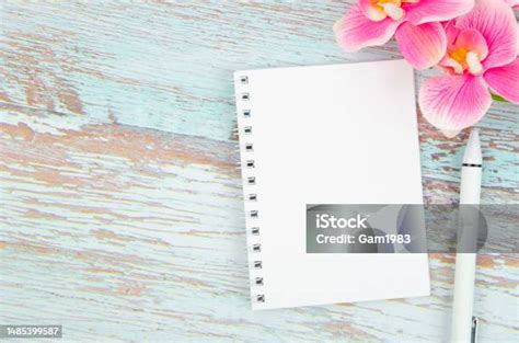 하얀 페이지와 파란 나무 배경에 밝은 분홍색 난초 꽃이 있는 빈 공책의 평면도 0명에 대한 스톡 사진 및 기타 이미지 0명