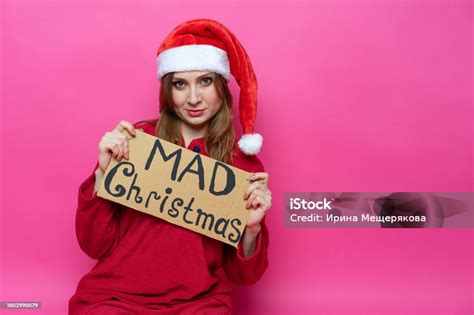 현수막을 들고있는 산타 모자를 쓴 미소 짓는 여자 미친 크리스마스 나쁜 기분 휴일 블루스 25 29세에 대한 스톡 사진 및 기타 이미지 25 29세 고독 부정적인 감정