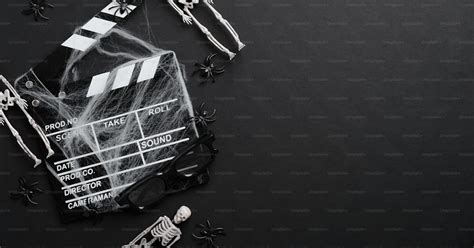 할로윈 개념입니다 거미줄에 영화 클래퍼 보드가 있는 무서운 플랫 레이 구성 검은색 배경에 해골 사진 Unsplash의 프레임 테두리 이미지