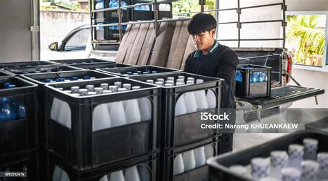 Thai Asian Workers Lift White Drinking Water Bottles In Crates Into The