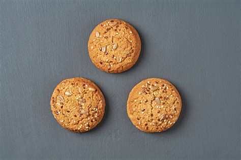 삼각형의 형태로 해바라기와 참깨의 씨앗과 세 신선한 수제 쿠키는 부엌에 어두운 긁힌 콘크리트 테이블에 놓여있다 맨 위 보기 클로즈업 3가지 개체에 대한 스톡 사진 및 기타