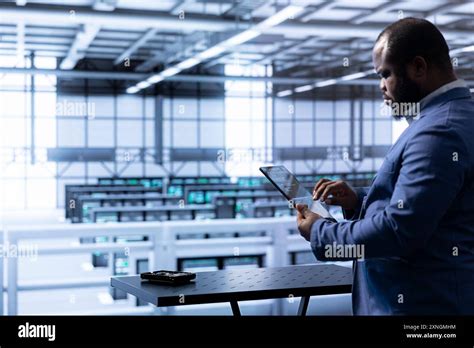 Engineer In Data Center Using Tablet To Identify And Solve Technical Issues Related To Data