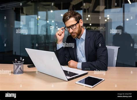 Serious Thinking Senior Businessman Working Inside Office Using Laptop