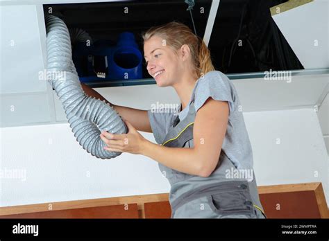 Female Worker Fitting Ventilation System In Buildings Ceiling Stock Photo Alamy