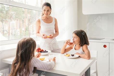 Mother And Daughters Enjoying A Delicious Fruit Dessert 이미지 601925200
