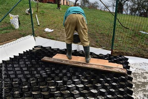 Pouring Crushed Stone Into The Plastic Net And Compacting The Plastic