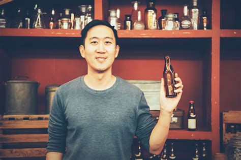 아시아 남자 펍이 나 바 배경 위에 알콜 음료의 병을 들고 펍 소유자 쾌활 한 캐릭터와 함께 웃 고 바텐더에 대한 스톡 사진 및 기타 이미지 Istock