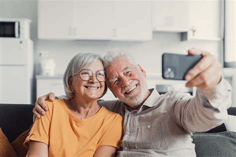 핸드폰으로 셀카를 찍는 행복한 노부부 웃고 있는 고위 성숙한 배우자 중년의 아내와 은퇴한 남편이 전화를 들고 웃고 있다 스마트폰 카메라에 자화상을 만들고 모바일 디스플레이에