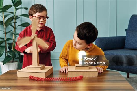 귀여운 아이는 청정 에너지를위한 풍력 터빈을 발명했다 터빈은 바람과 함께 회전하고 전구에 조명 2 3 살에 대한 스톡 사진 및 기타 이미지 Istock