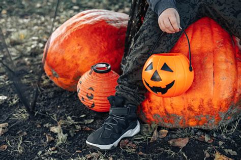 할로윈 아이 잭 O 랜턴 초콜릿의 바구니는 아이의 손에 거대한 못생긴 호박의 배경에 귀여운 어린 소년 오렌지 잭 O 랜턴 사탕 양동이와 마녀 모자를 입고 아이 10월에 대한