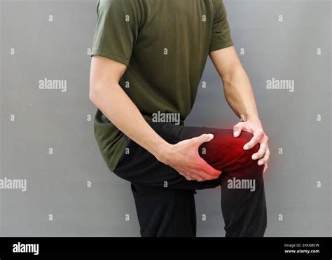 A Man Holding His Injured Knee The Injured Area Is Highlighted In Red