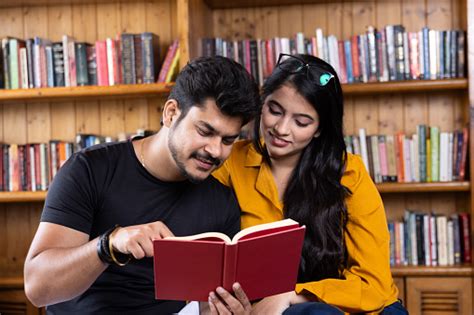 도서관이나 카페 또는 사무실 도서관에서 벤치나 스툴에 앉아 책을 읽고 있는 젊은 커플 재택근무에 대한 스톡 사진 및 기타 이미지 재택근무 20 24세 25 29세