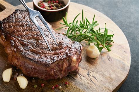 스테이크 회색 배경에 검은 대리석 보드에 향신료 로즈마리와 후추를 곁들인 구운 뉴욕 스테이크 상단 보기 모의 0명에 대한 스톡