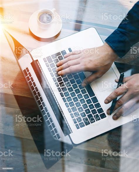 밝은 사무실에 노트북에서 일 하는 남자 남자 손은 키보드에 입력입니다 현대 노트북 나무 테이블에 블랙 커피 한잔 유리 표면에 반사입니다 수직입니다 가상현실에 대한 스톡 사진