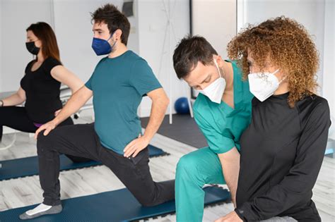 그들의 물리 치료를하는 동안 얼굴 마스크를 착용 재활 센터에서 의사와 환자의 그룹 고품질 사진 3 명에 대한 스톡 사진 및 기타 이미지 Istock