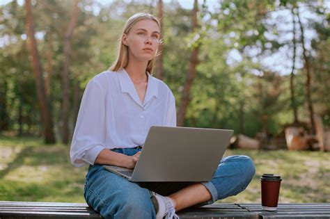노트북 온라인 에 공원에서 일하는 매력적인 여성은 그녀가 자연에서 시간을 즐기는 몇 가지 문서를 입력 집중 남자 사업가에 대한
