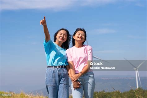 푸른 하늘이 있는 풍력 터빈과 산을 바라보며 함께 서 있는 행복한 두 소녀 Khao Yai Thieng 전기 풍력 터빈 태국 16 17 살에 대한 스톡 사진 및 기타 이미지