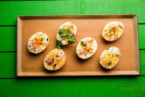 튀긴 뜨거운 삶은 계란 Masala는 인기 있는 건강 한 아침 식사 또는 인도에서 시작 메뉴 양파 고 수 후추 토마토와 소금 뿌려 이상 계란의 절반 0명에 대한 스톡 사진