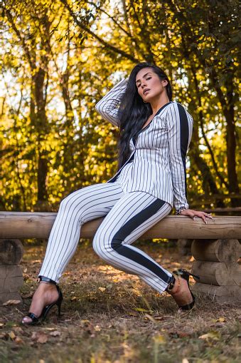 여름 라이프 스타일 검은 줄무늬와 매우 우아한 흰색 정장에 젊은 라틴어 갈색 머리 소녀 아름다운 공원 앉아 패션 에디토리얼에서 포즈를 취한 패션 35 39세에 대한 스톡