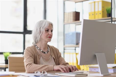 Woman With Grey Hair Looks At Screen Of Computer Monitor Stock Image Image Of Finance