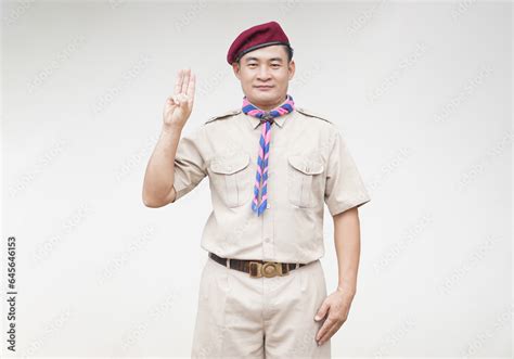 Handsome Asian Man Wear Boy Scout Uniform Red Cap Blue And Pink Striped Scarf Make Hand Sign