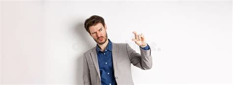 Businessman Trying To See Something Tiny Showing Small Thing Size With Fingers Standing In