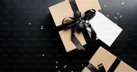 크리스마스 선물과 색종이 조각이 있는 검은색 배경에 빈 종이 카드 모형 크리스마스 선물 사진 Unsplash의 묶인 활 이미지